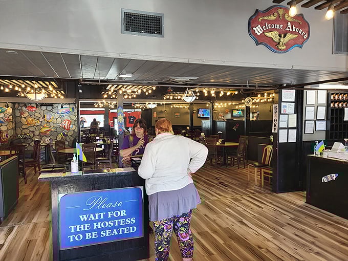 "Welcome Aboard" indeed! The warm wooden interior with twinkling string lights creates the perfect backdrop for your imminent seafood adventure.