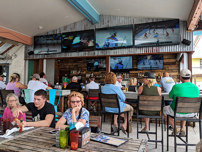 The rustic bar area combines weathered wood, corrugated metal, and multiple TVs&mdash;a perfect spot for catching the game while catching up with friends.