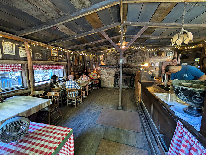 Inside, string lights twinkle above wooden beams like stars in a frontier sky, while red-checkered tablecloths promise comfort food that predates Instagram by centuries.