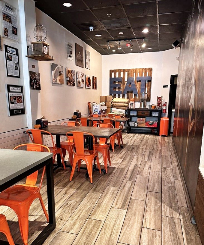 Orange chairs pop against rustic wood floors in this cozy space. It's like your cool friend's dining room, if your friend happened to be a barbecue savant.