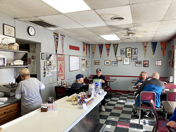 Classic diner perfection: checkered floors, counter seating, and sports pennants create that rare atmosphere where strangers become neighbors and calories don't count.