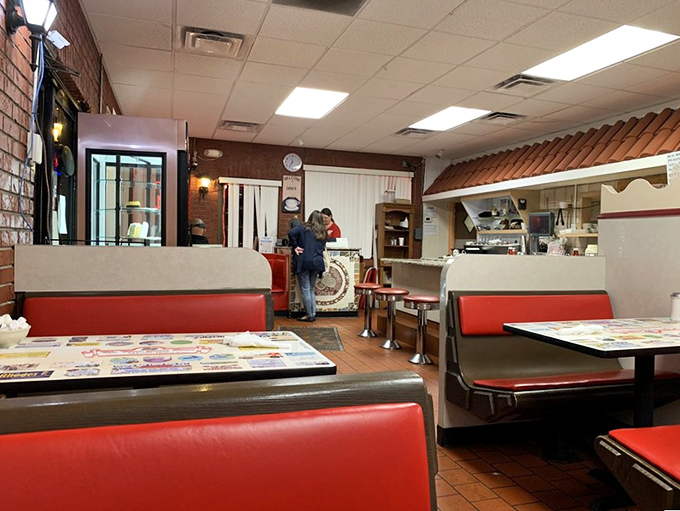 Classic red vinyl booths and warm wood paneling create that timeless diner atmosphere where conversations flow as freely as the coffee.