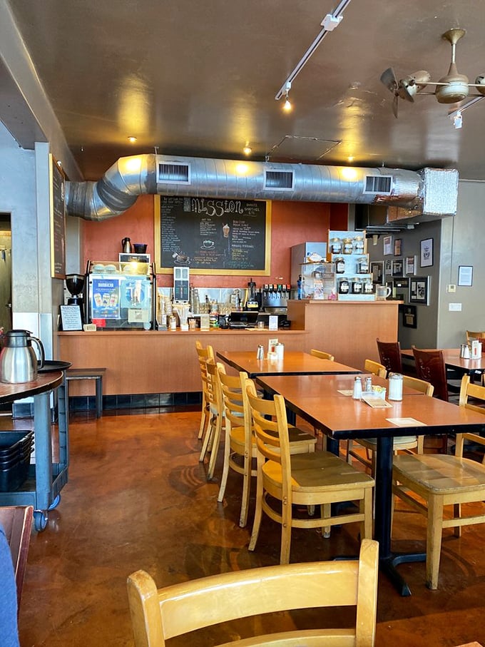 Industrial chic meets morning comfort inside The Mission, where exposed ductwork watches over wooden tables as coffee aromas dance through the air.
