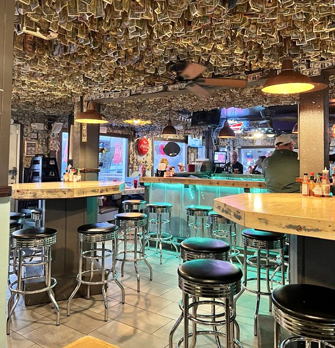 Dollar bills create a canopy of memories while chrome stools await your next oyster adventure.