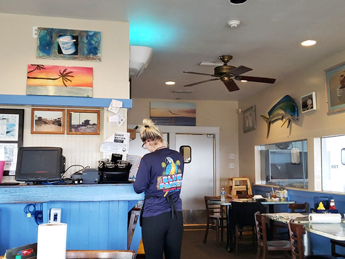 The interior speaks volumes: mounted fish, sunset paintings, and that signature blue bar&mdash;this place knows exactly what it is.