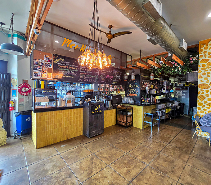 Inside, industrial meets cozy with exposed ducts, Edison bulbs, and that signature yellow tile counter where breakfast dreams come true.