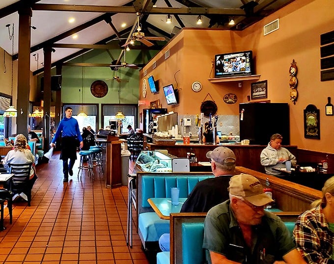 High ceilings, warm orange walls, and those retro turquoise booths create the perfect backdrop for the daily ritual of locals swapping stories over steaming coffee.