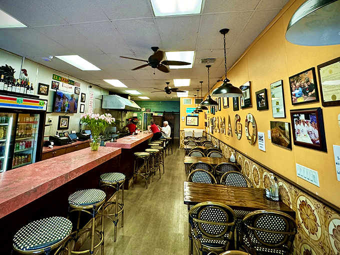 Yellow walls adorned with memories and the restaurant's name in bold letters create a warm, inviting atmosphere that feels like Cuba's living room.