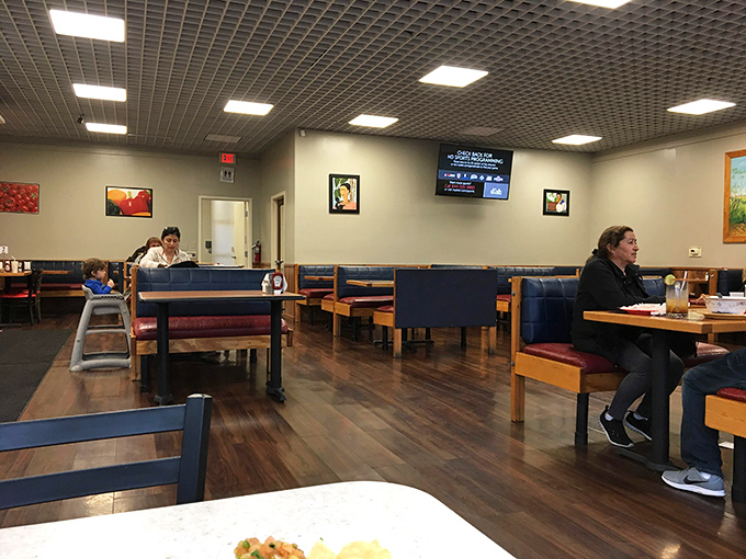 The dining room's unpretentious charm—blue booths, wooden tables, and just enough art to remind you that comfort trumps trendiness when the food is this good.