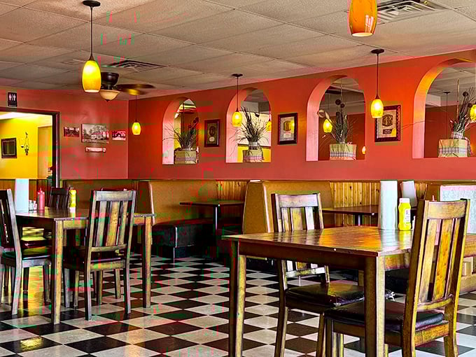 Coral walls, pendant lighting, and that classic checkered floor create the perfect backdrop for burger bliss. This isn't Instagram-bait d&eacute;cor; it's the real-deal comfort zone.