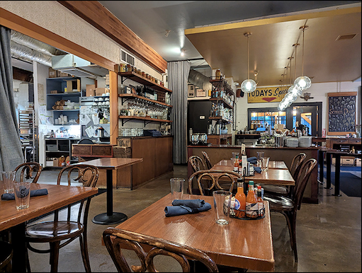 Warm wooden tables, classic bentwood chairs, and an open bar create that perfect balance of rustic charm and urban sophistication that makes you want to linger.