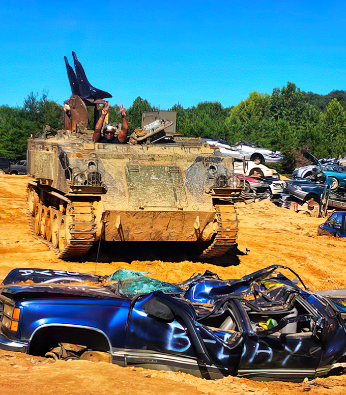 "Office views vary greatly in this line of work." Visitors celebrate their vehicular conquest atop a tank while a flattened car serves as their trophy.