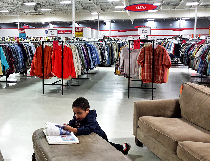 The men's section stretches into infinity, a sea of potential style upgrades. Even the youngest shoppers find comfortable spots to take a literary break.