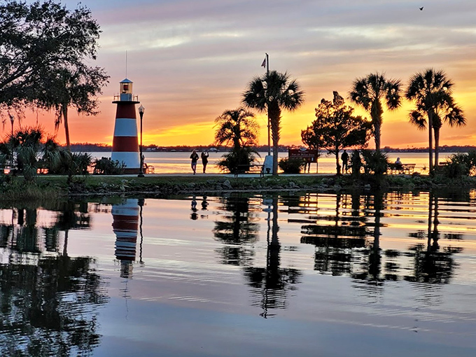 Nature's light show reflects off Lake Dora at sunset, with the lighthouse standing guard like Florida's answer to a Norman Rockwell painting.