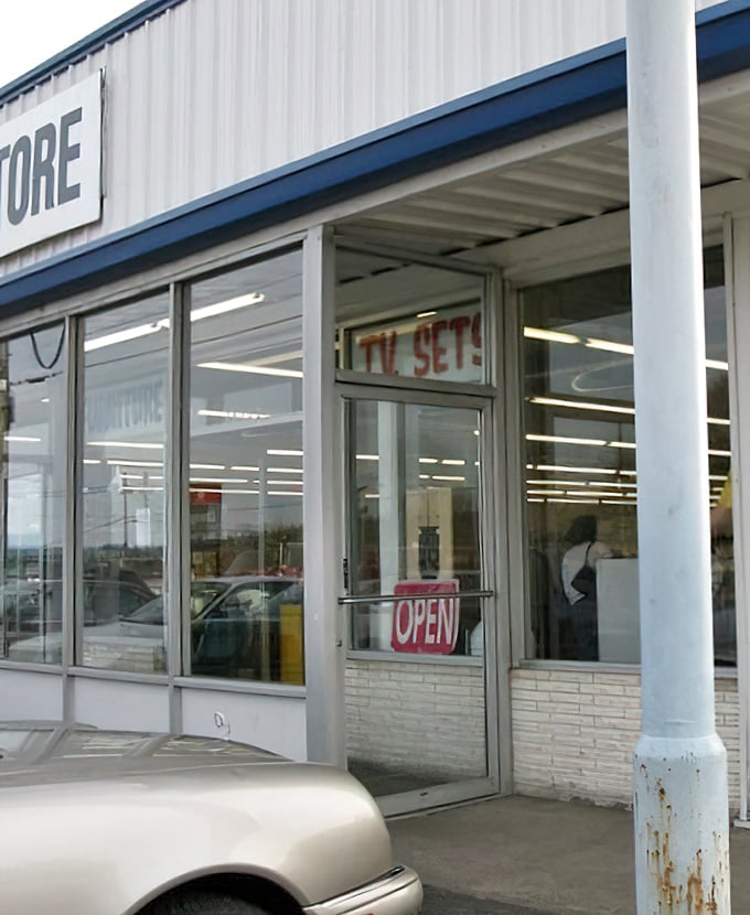 "TV SETS" proclaims the window sign, a portal to entertainment history where yesterday's technology finds tomorrow's appreciative audience.