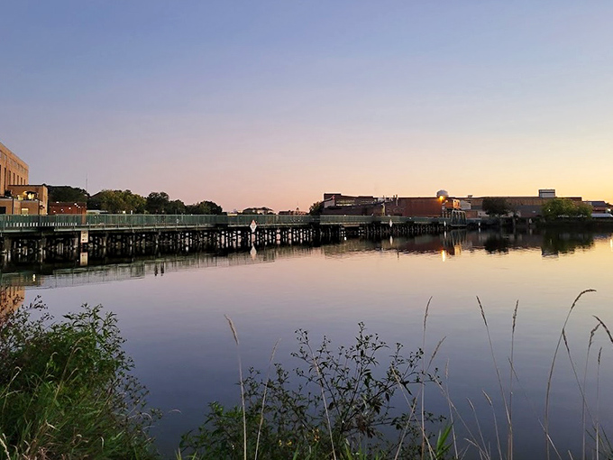 Sunset transforms the Rock River into a mirror of tranquility, reflecting Beloit's riverside buildings in a moment of perfect stillness.