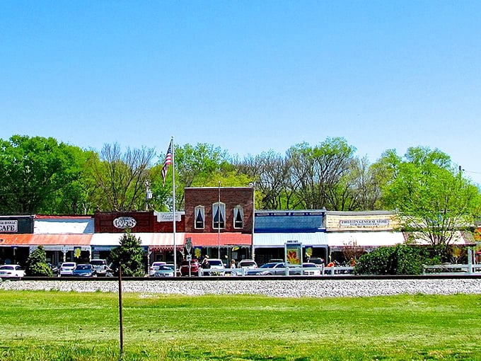 Where the railroad meets Main Street, Bell Buckle's charming row of shops basks in Tennessee sunshine, American flag proudly waving.