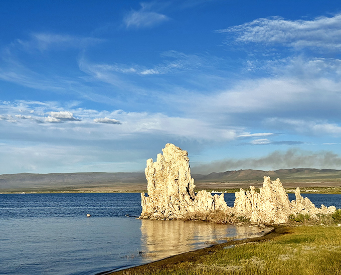 This solitary tufa formation stands like a limestone sentinel, guarding secrets of the ancient lake while reflecting perfectly in the still waters.