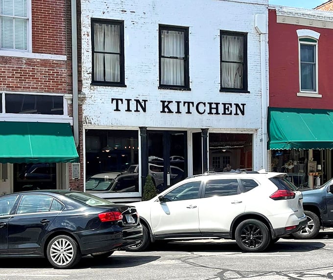 The Tin Kitchen's weathered white exterior belies the culinary treasures within. This local favorite serves up sophisticated comfort food that would make your grandmother both proud and jealous.