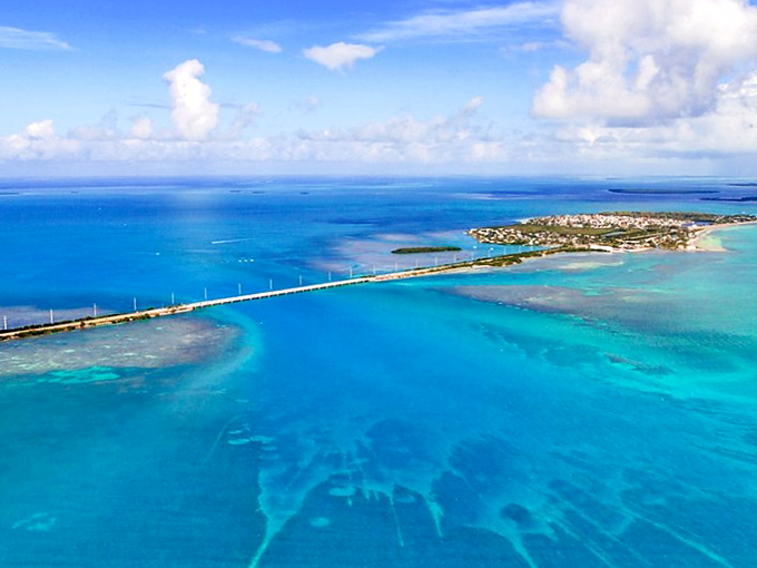 Nature's own watercolor masterpiece unfolds beneath you, where the Atlantic and Gulf play a game of who-can-be-more-turquoise.