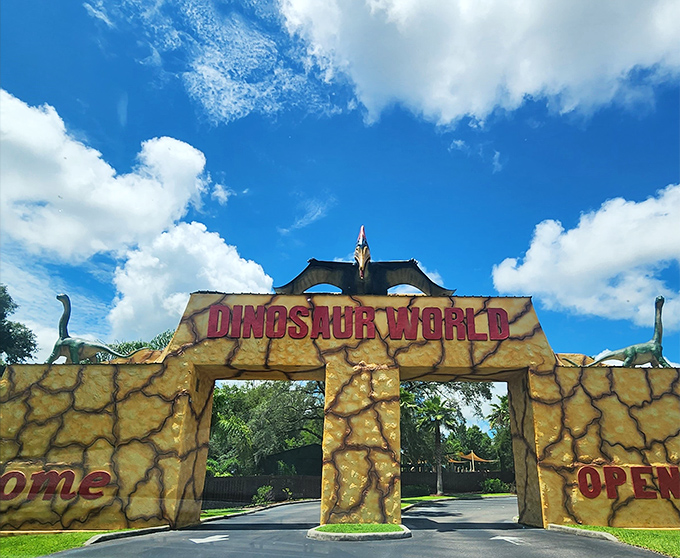 The entrance to prehistoric paradise beckons under Florida's impossibly blue skies. This stone archway is basically a time machine disguised as a theme park gate.