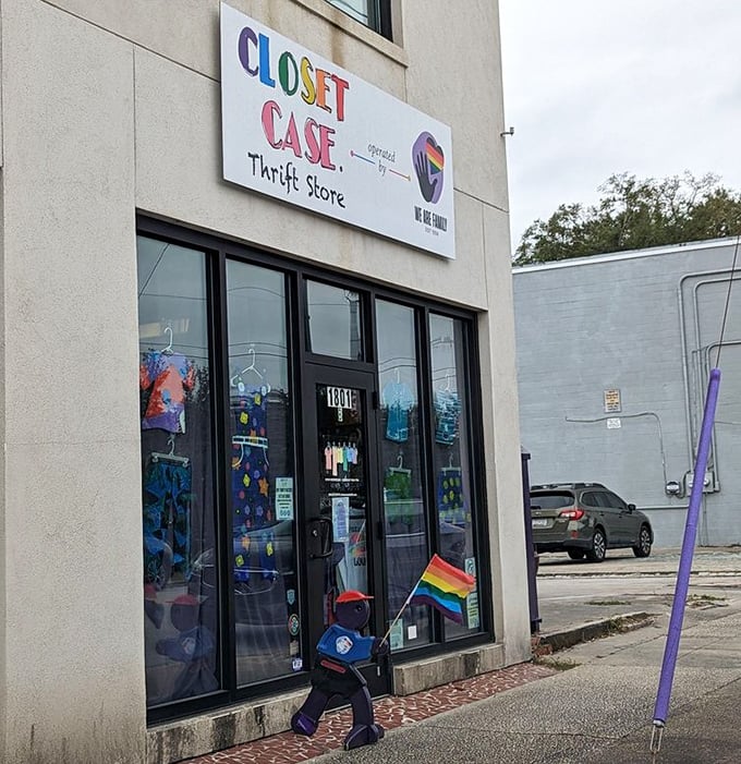 Rainbow-hued signage and a welcoming entrance set the stage for thrifting adventures. That little figure with the flag? Pure joy in motion.