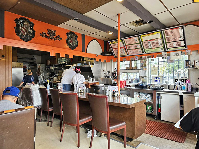 Orange walls and counter seating create that perfect diner atmosphere where breakfast dreams come true and coffee cups never stay empty.