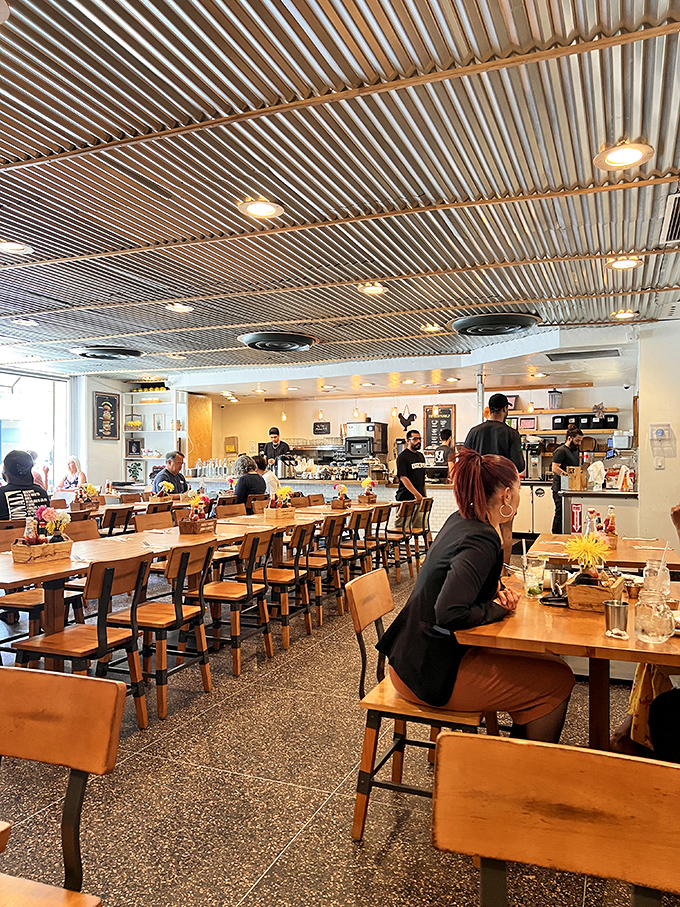 Industrial chic meets comfort food haven. The corrugated metal ceiling and wooden tables create the perfect backdrop for breakfast bliss.
