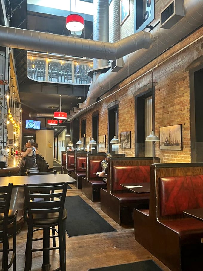 Industrial chic meets cozy comfort inside, where exposed brick and ductwork create the perfect backdrop for serious burger business.