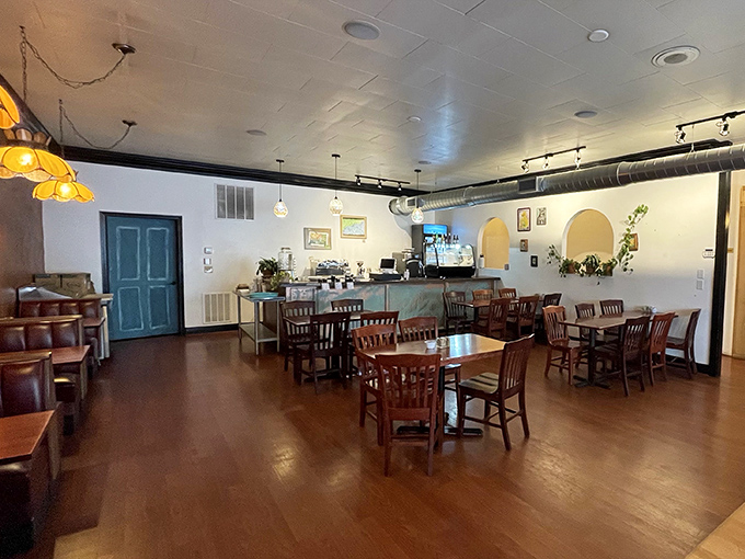 Simplicity reigns in this warm, inviting space where wooden tables, pendant lighting, and exposed ductwork create the perfect backdrop for culinary magic.