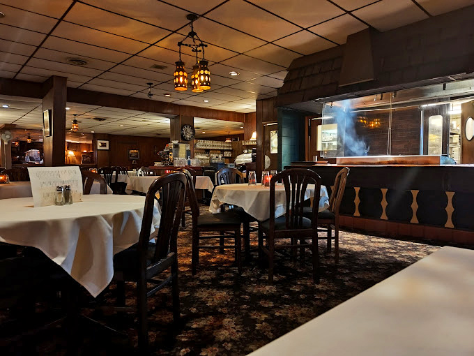 Classic supper club ambiance in full effect&mdash;white tablecloths, warm wood tones, and lighting dim enough to make everyone look like they've made excellent life choices.