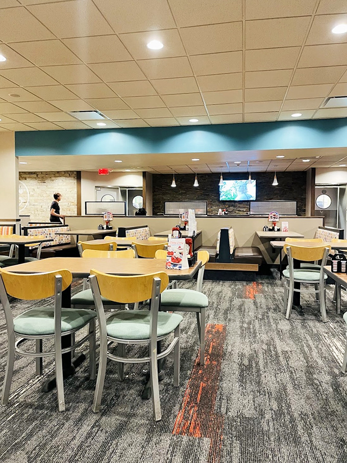 Inside, the modern yet cozy dining area invites you to settle in with its warm color palette and comfortable seating arrangement.