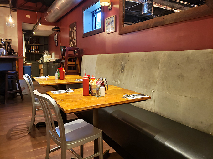 Cozy wooden tables, red walls, and bench seating create that perfect "stay awhile" vibe where breakfast dreams become delicious reality.