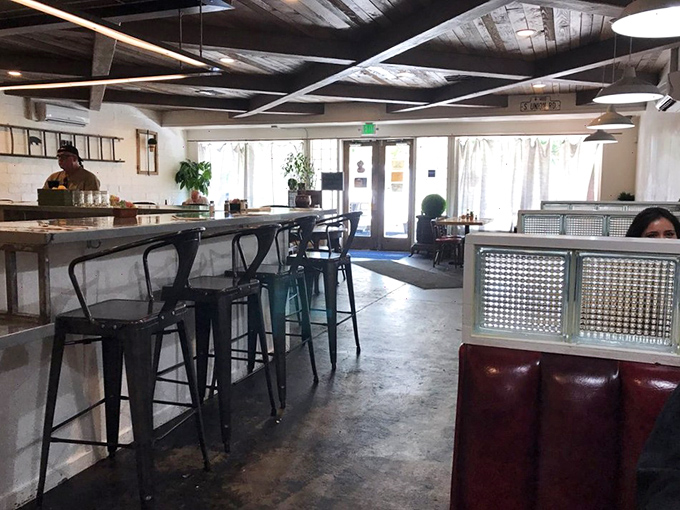 Industrial-chic meets comfort in this thoughtfully designed space where wooden ceiling beams and concrete floors create the perfect backdrop for breakfast bliss.