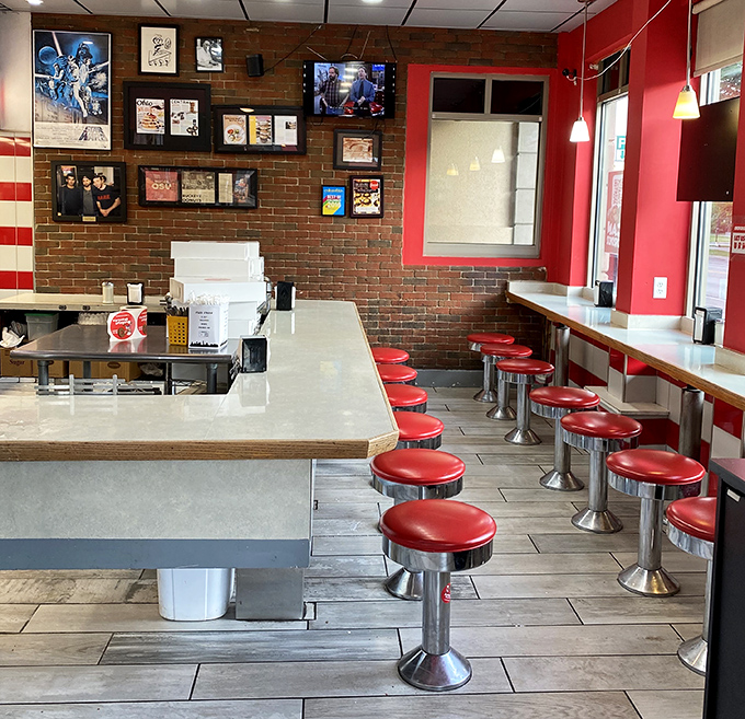 Classic diner seating with those unmistakable red stools—where strangers become friends over coffee and the mutual appreciation of fried dough.