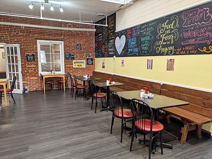 Exposed brick walls meet colorful chalkboard wisdom in this dining room where every table feels like the best seat in the house.