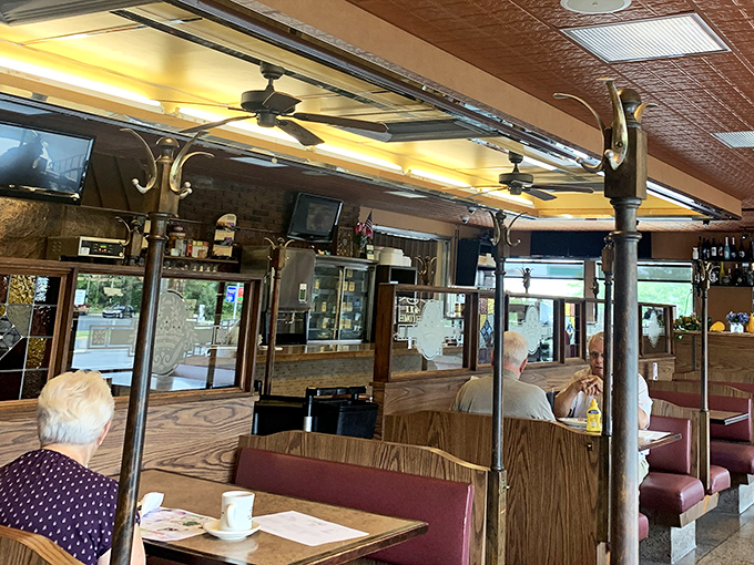 Inside, burgundy booths and wooden partitions create that perfect diner atmosphere where conversations flow as freely as the coffee refills.