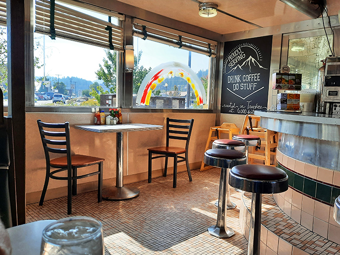 Retro charm meets mountain views at this counter seating area, where the rainbow painted window promises colorful culinary experiences inside.