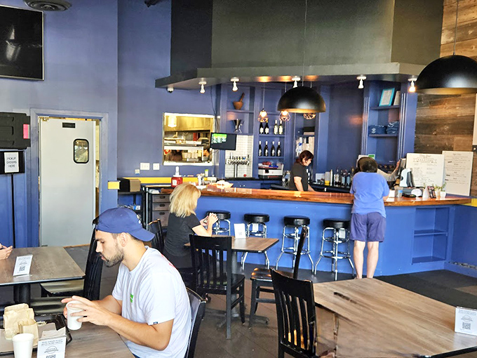 Blue walls, wooden tables, and pendant lighting create the perfect backdrop for the burger magic that happens behind that counter.