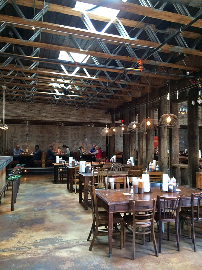 Industrial chic meets meat sanctuary. Exposed beams, Edison bulbs, and communal tables create the perfect backdrop for the serious business of barbecue appreciation.