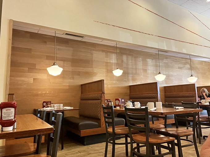 Modern meets cozy in a dining room where wood panels whisper "stay awhile" and pendant lights spotlight your pancake moment.