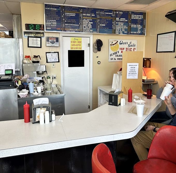 Behind this counter, burger magic happens daily. The "No Complaining" sign says it all&mdash;who could possibly complain when paradise comes on a bun?