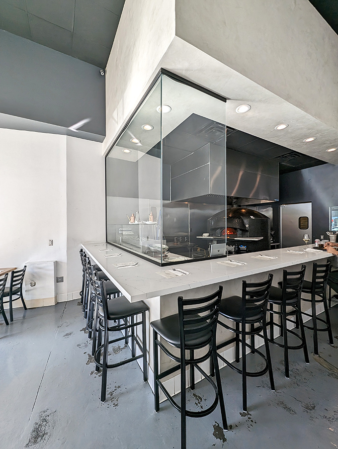 The heart of pizza perfection: Pizzeria Sei's open kitchen invites diners to witness the magic happening behind that gleaming glass enclosure.