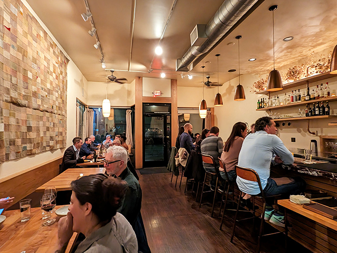 Warm copper pendants cast a honey-colored glow over diners deep in conversation. The kind of lighting that makes everyone look like they've just returned from vacation.