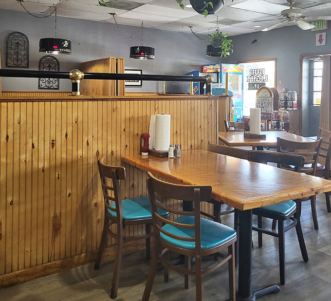 Pine paneling and turquoise chairs create that perfect "come as you are" vibe where comfort trumps pretension every time.