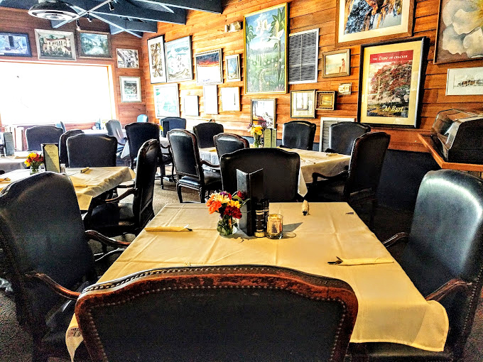 White tablecloths meet rustic wood paneling in this dining room where local artwork tells stories of Florida's waters. Casual elegance at its finest.