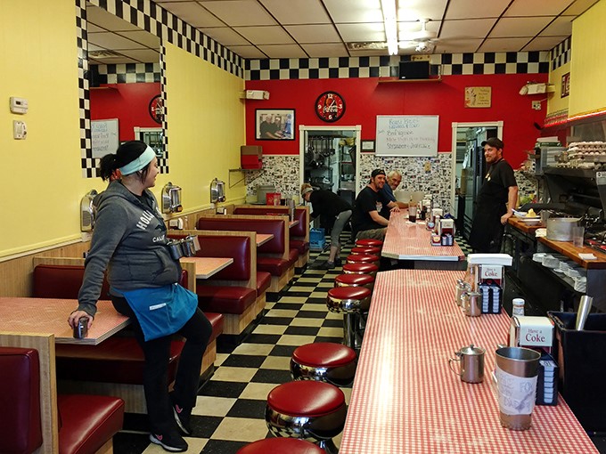 Classic black and white checkerboard floors meet red vinyl booths in this time capsule where conversations flow as freely as the coffee.