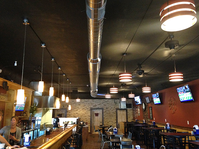 Industrial chic meets hometown comfort in this inviting space. The exposed ductwork and pendant lighting say "trendy," but the atmosphere whispers "stay awhile, old friend."