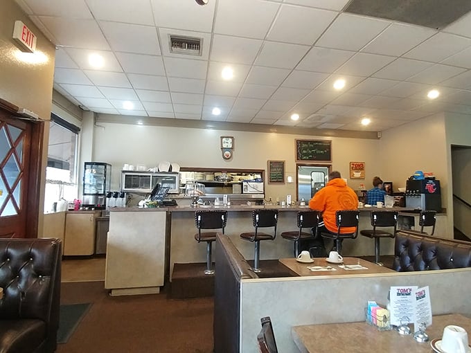 Classic counter seating where regulars perch like birds on a wire, watching breakfast magic unfold in the kitchen beyond.