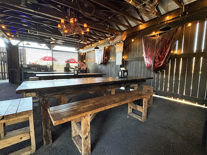 Rustic wooden tables under a chandelier? It's like your cool uncle's garage got a gourmet makeover while keeping all its character.
